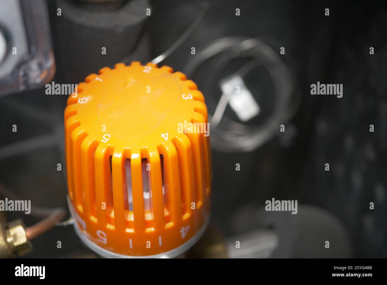 Bright orange dial on mechanical device in workshop setting Stock Photo ...