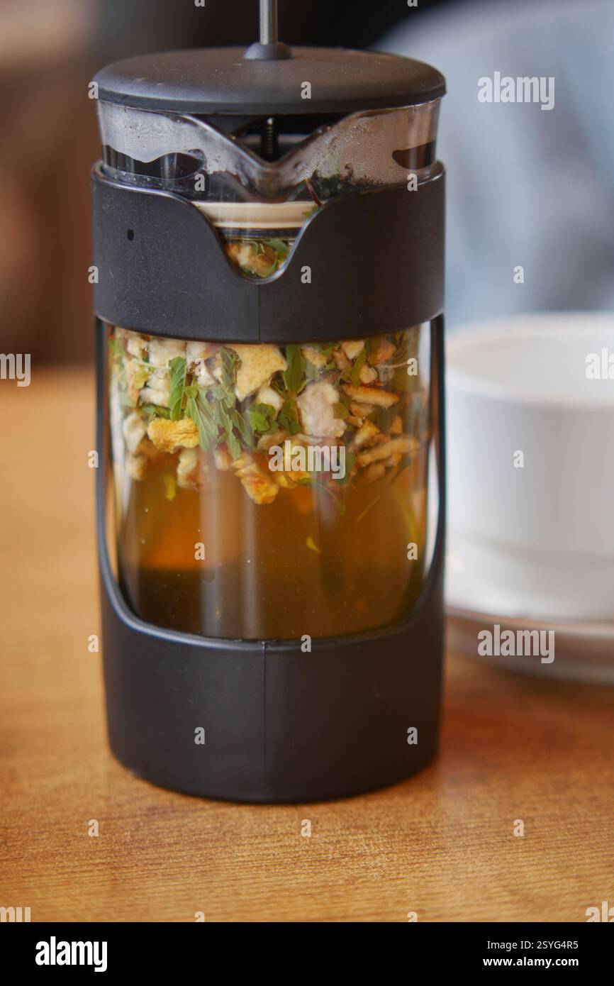 Brewing herbal tea in a french press at a cozy cafe setting Stock Photo ...