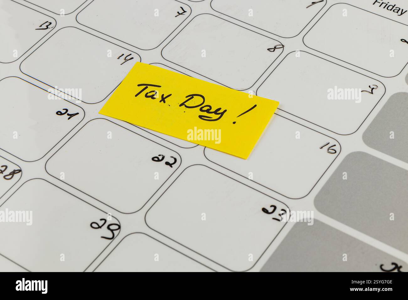 A yellow sticky note labeled Tax Day! is prominently placed on a ...