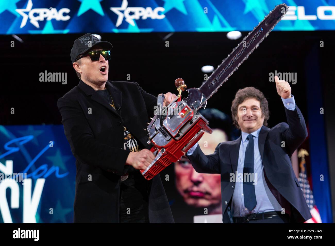 Elon Musk holds a chainsaw handed to him by Argentine President Javier ...