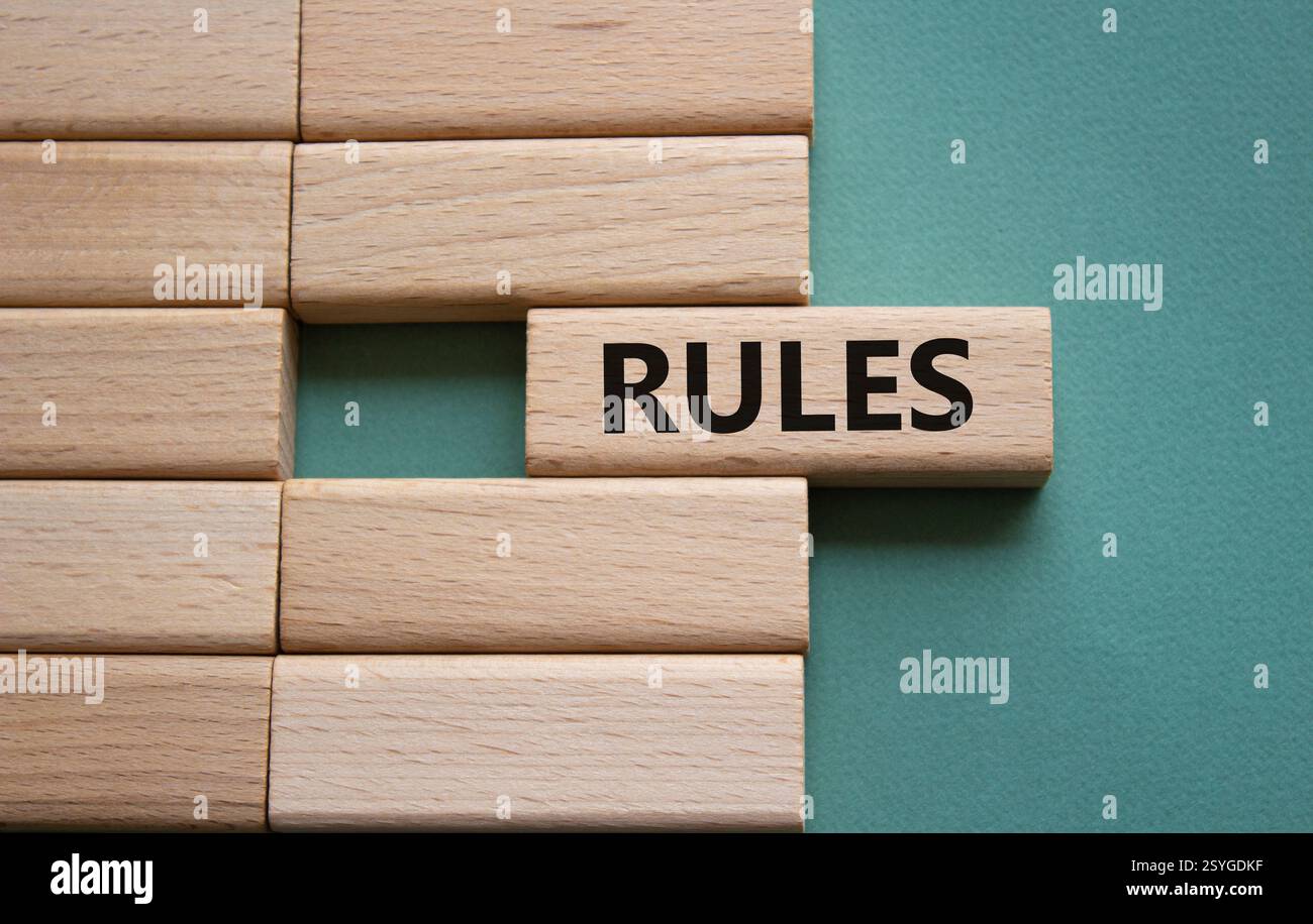 Rules symbol. Wooden blocks with word Rules. Beautiful grey green background. Rules concept ...