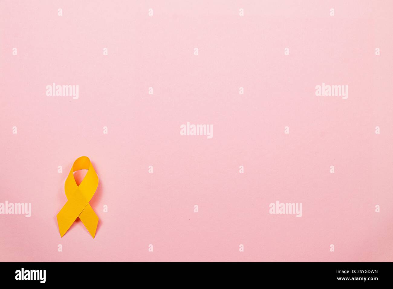 A bright yellow ribbon on a soft pink background represents hope and ...