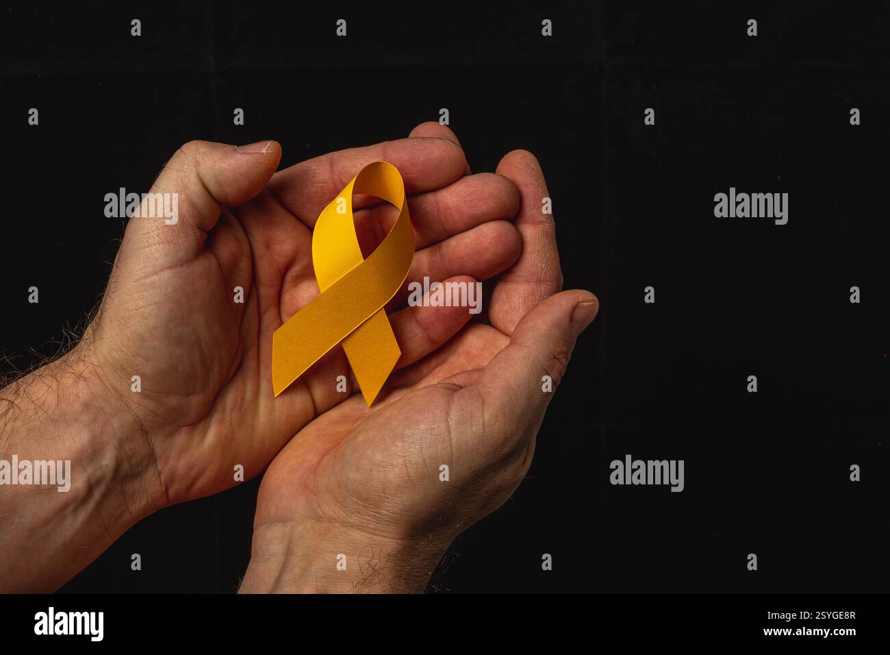 Two hands gently hold a yellow ribbon representing hope and solidarity ...