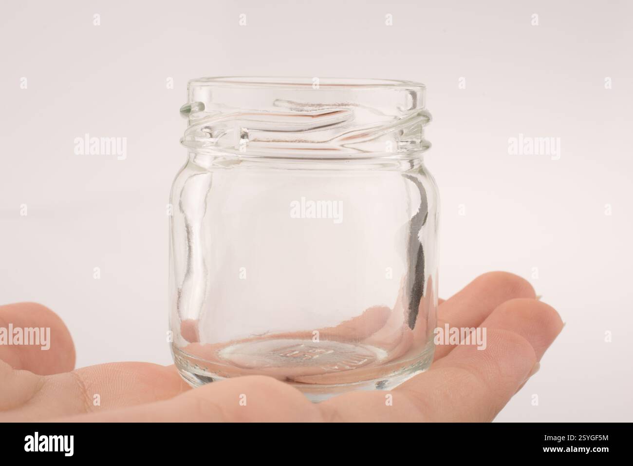 Little empty jar in hand on a white background Stock Photo - Alamy