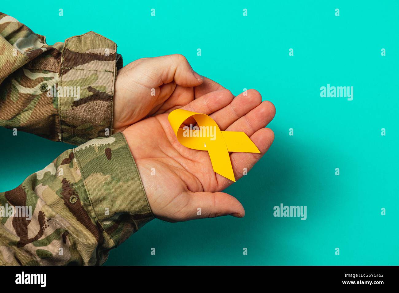 Two hands display a yellow ribbon on a blue background, representing ...