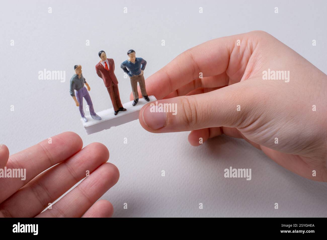 Tiny figurines of men miniature model in hand Stock Photo - Alamy