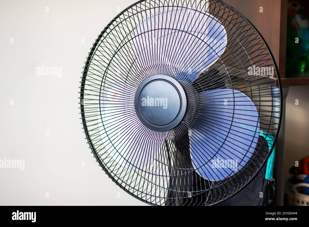 This image shows a close up of an electric fan positioned directly ...