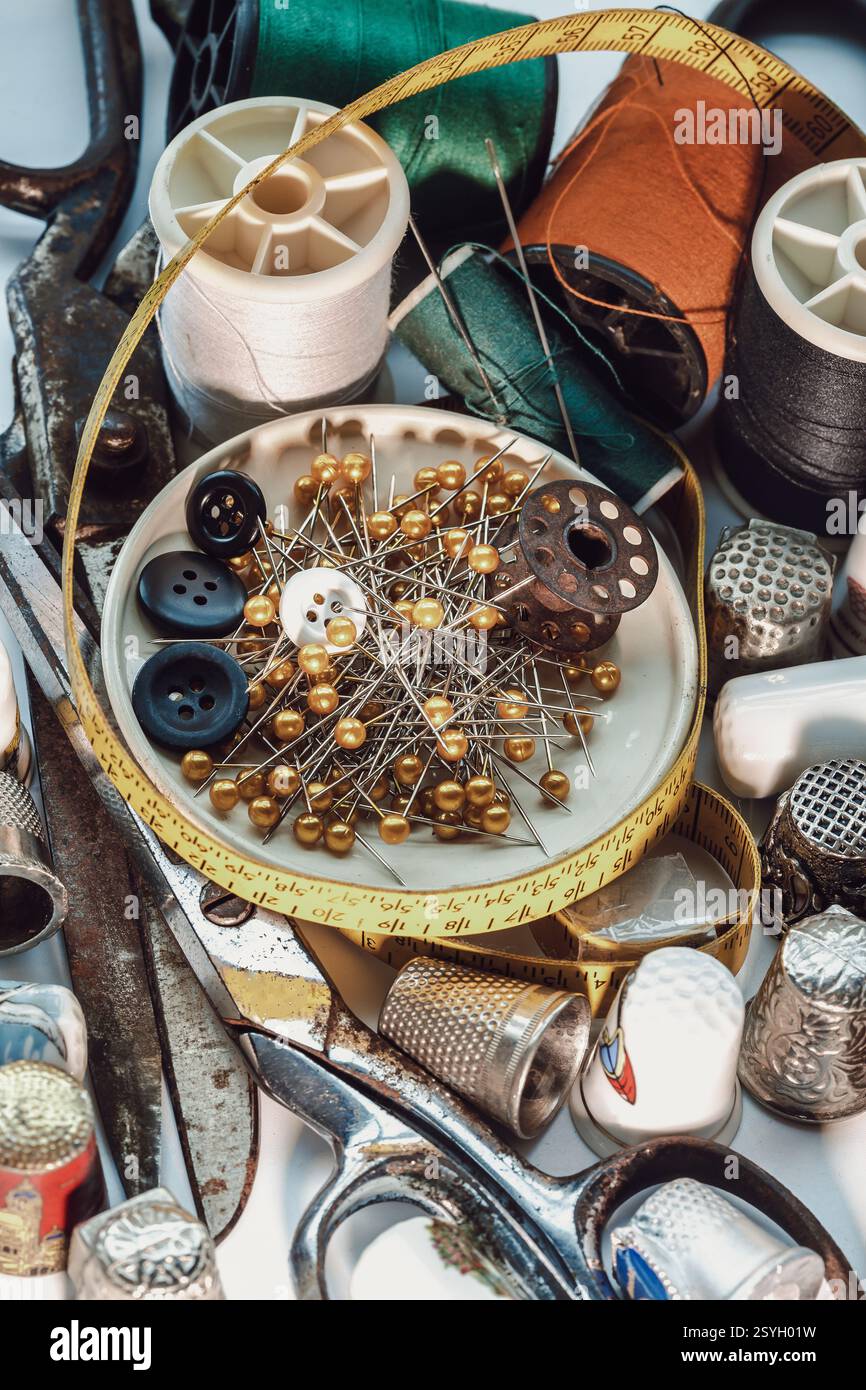 Sewing needles stuck in a green miniature spools thread Steel scissors ...