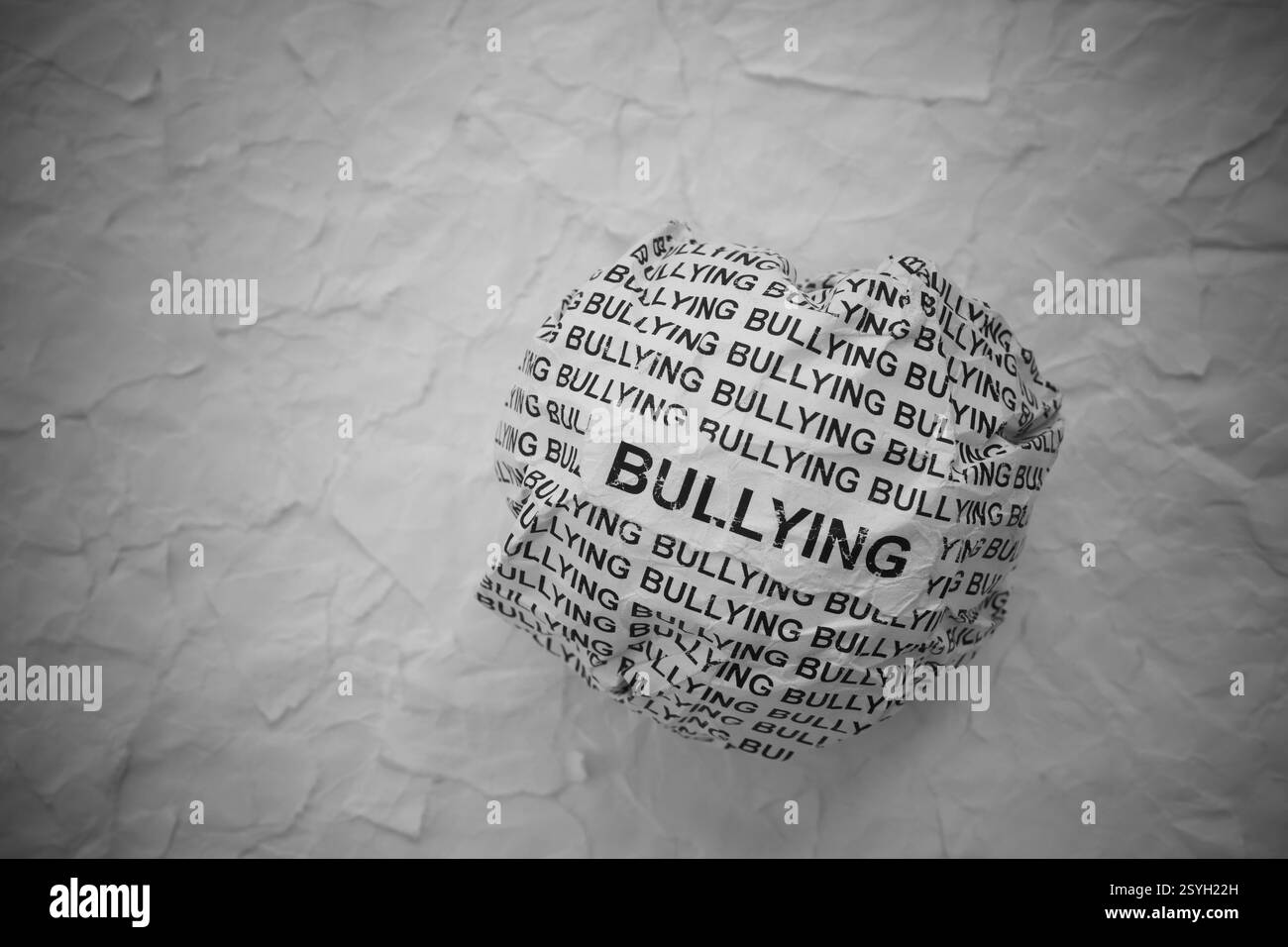 Crumpled paper ball with words Bullying on torn white paper pieces ...