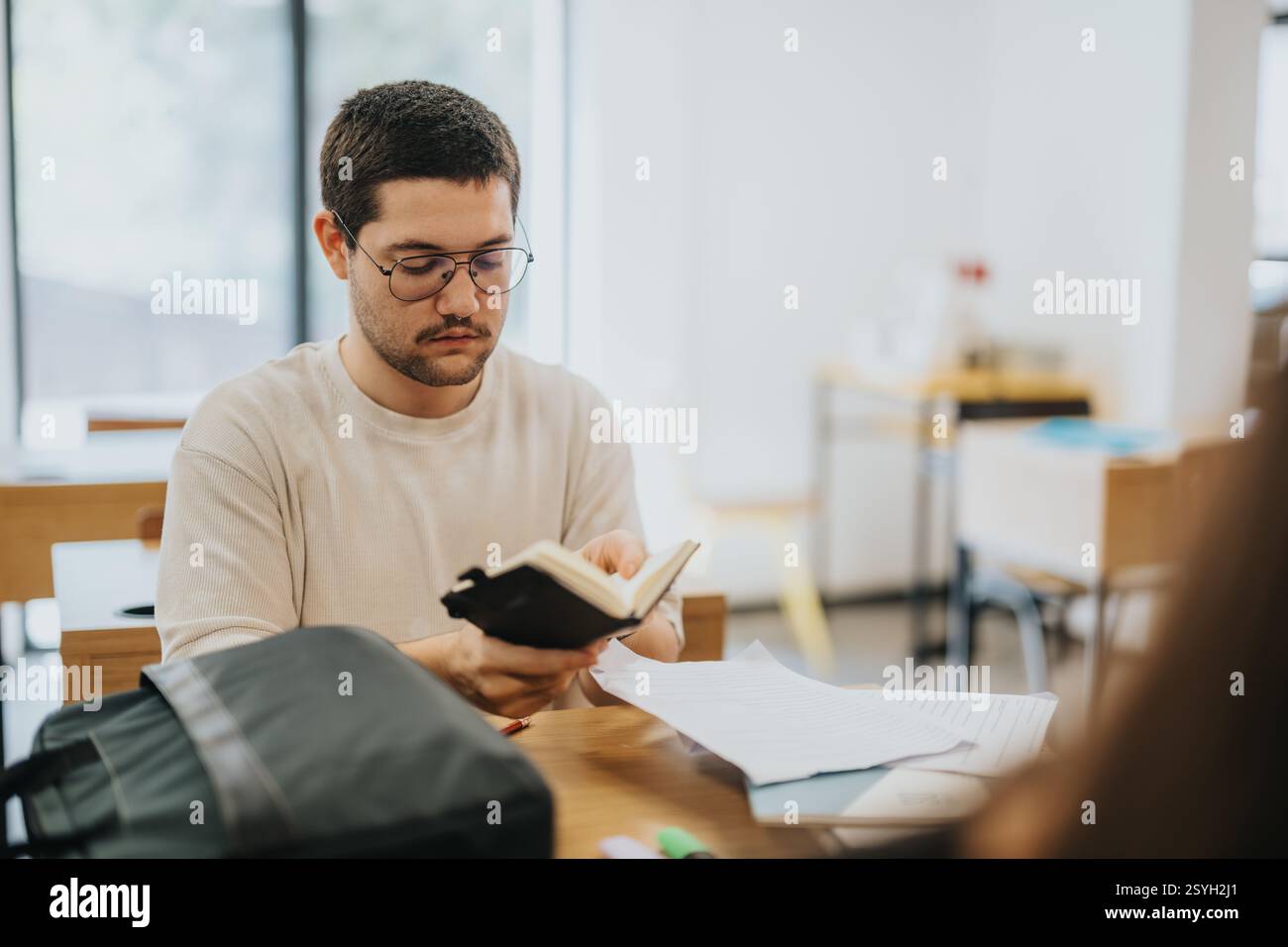 Focused high school student reading book in classroom setting Stock ...