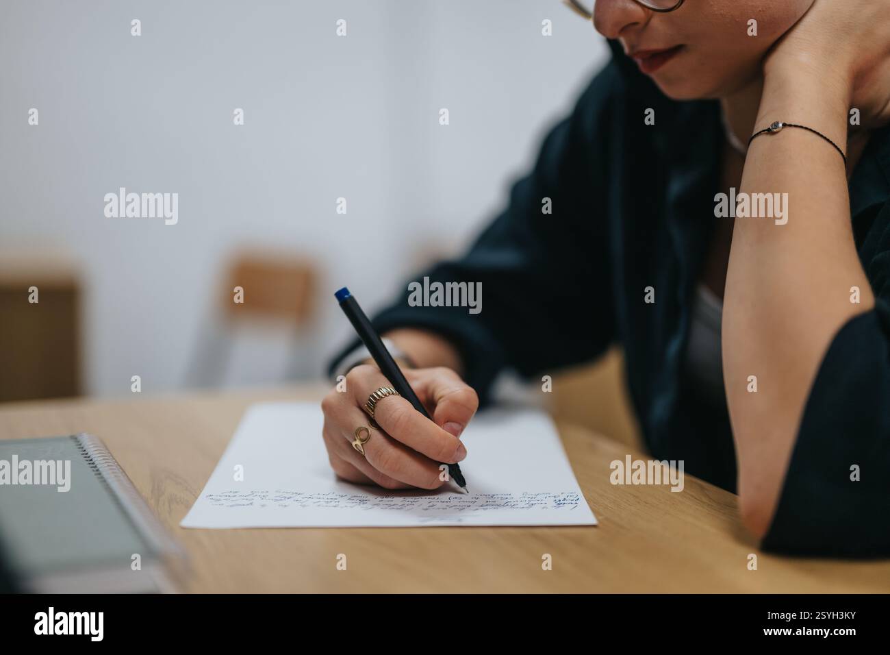 Focused student writing notes for a school assignment at desk Stock ...