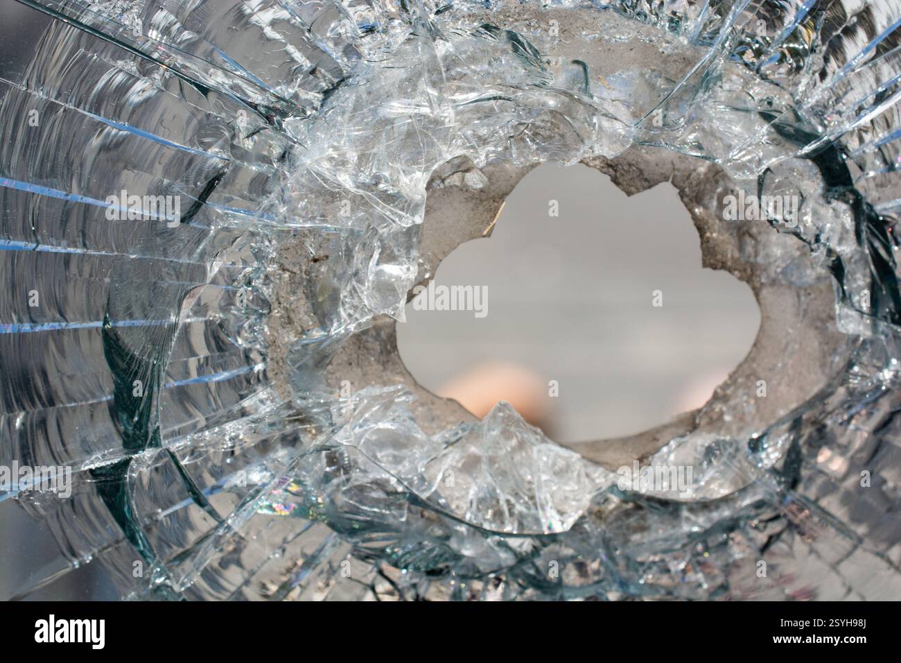 Damaged glass with a hole in shatters into small pieces Stock Photo - Alamy