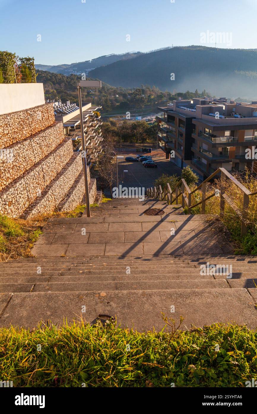 A stone staircase descends into a modern urban landscape featuring ...