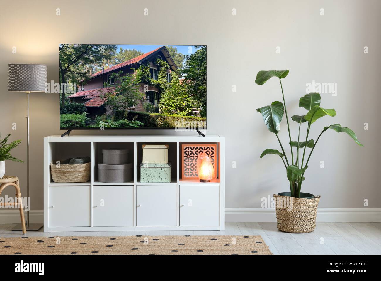 TV set with beautiful house on screen in room Stock Photo - Alamy
