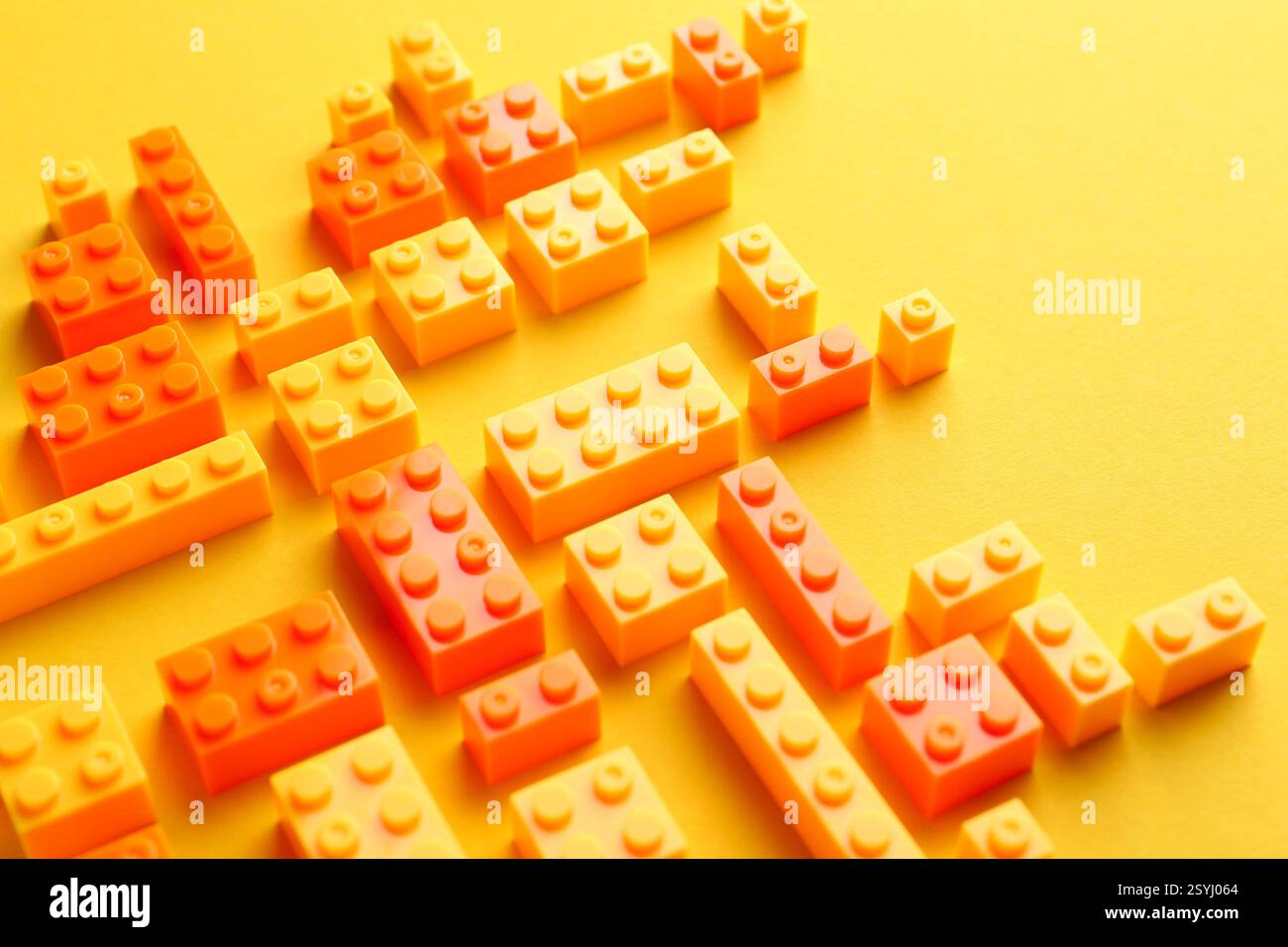 Constructor toy. Many building blocks on yellow background, above view ...