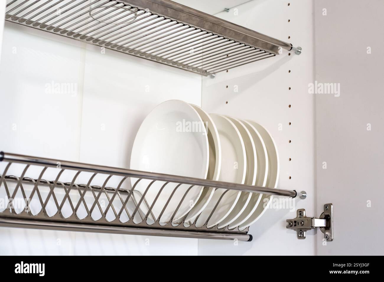 Kitchen white cabinet with drying racks with dishes. Organization of ...