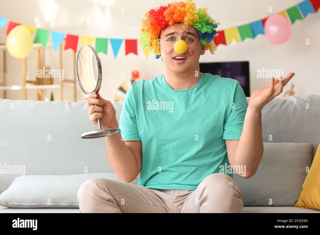 Shocked young man with colorful clown wig and paintings on his face at ...