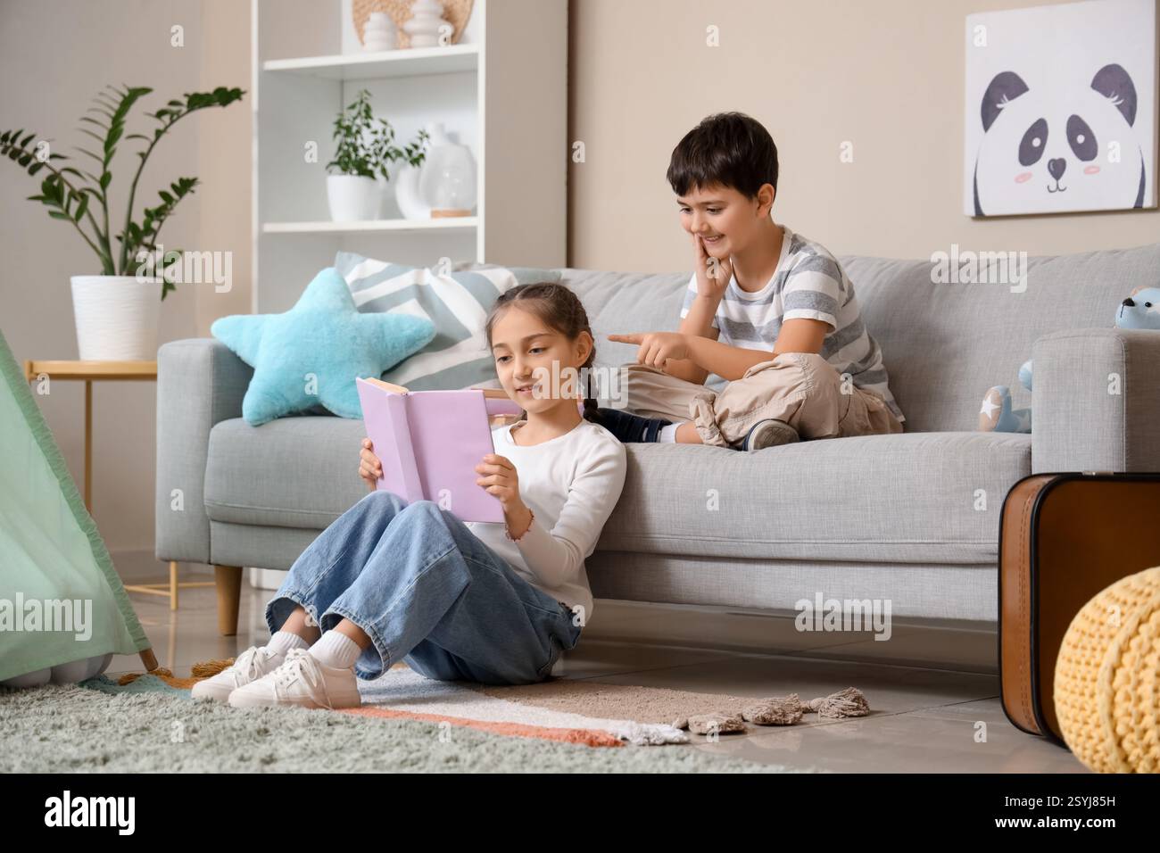 Cute children reading adventure book at home Stock Photo - Alamy