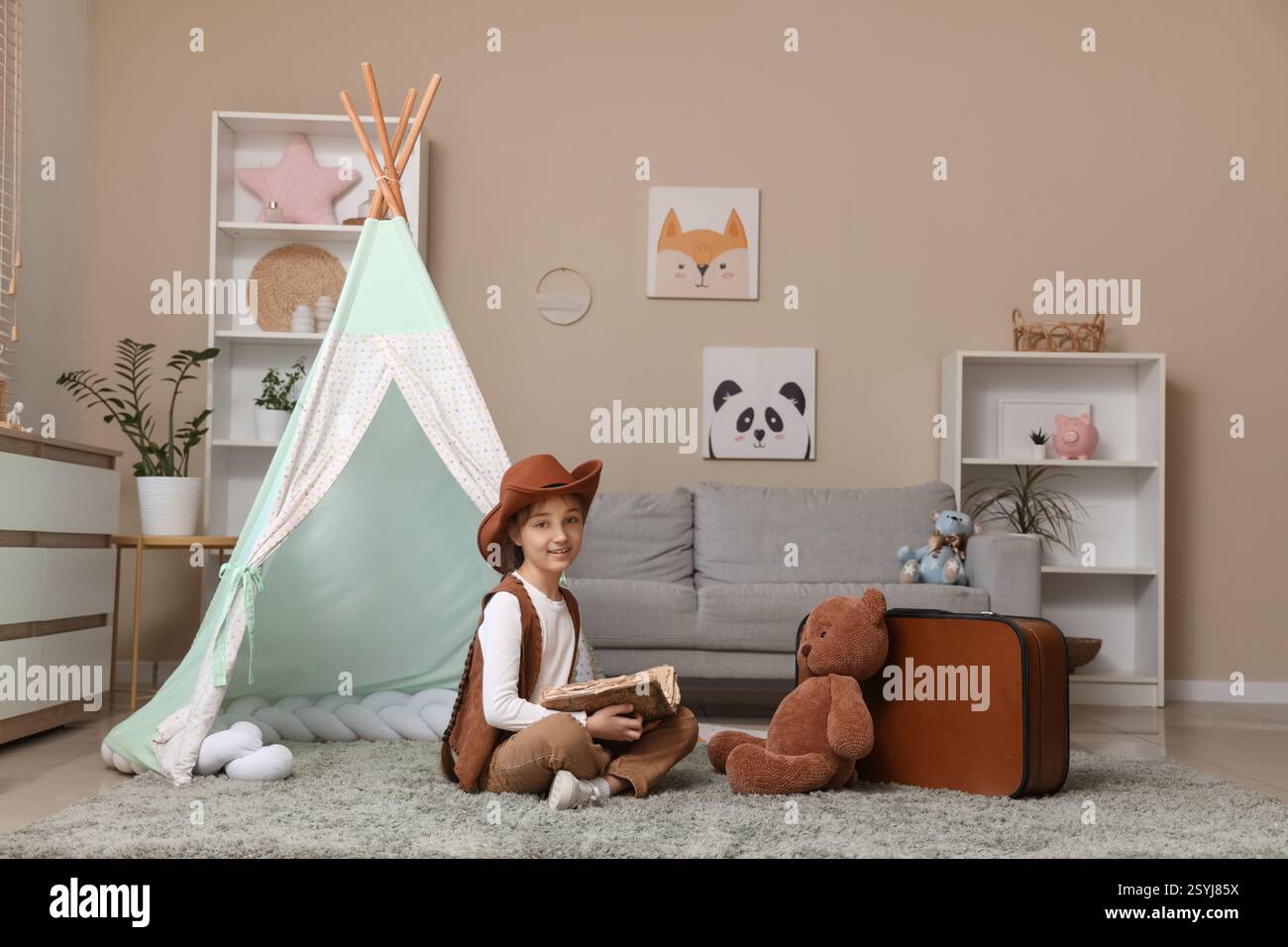 Cute girl dressed as cowboy reading adventure book at home Stock Photo ...
