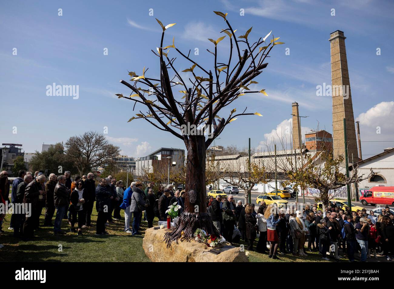 People gather around a memorial sculpture dedicated to the victims of a ...