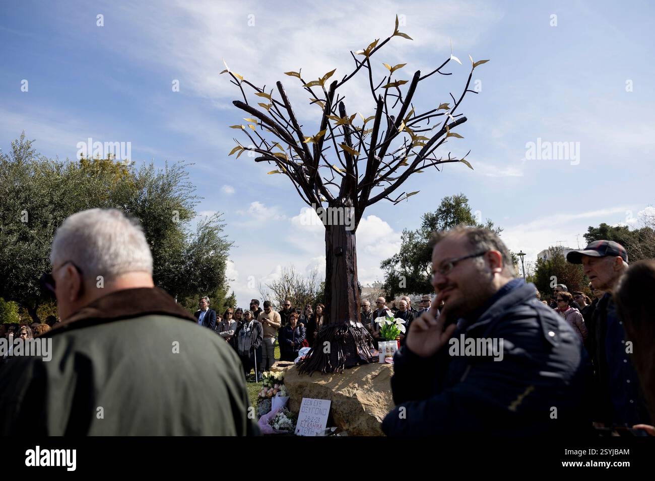 People gather around a memorial sculpture dedicated to the victims of a ...