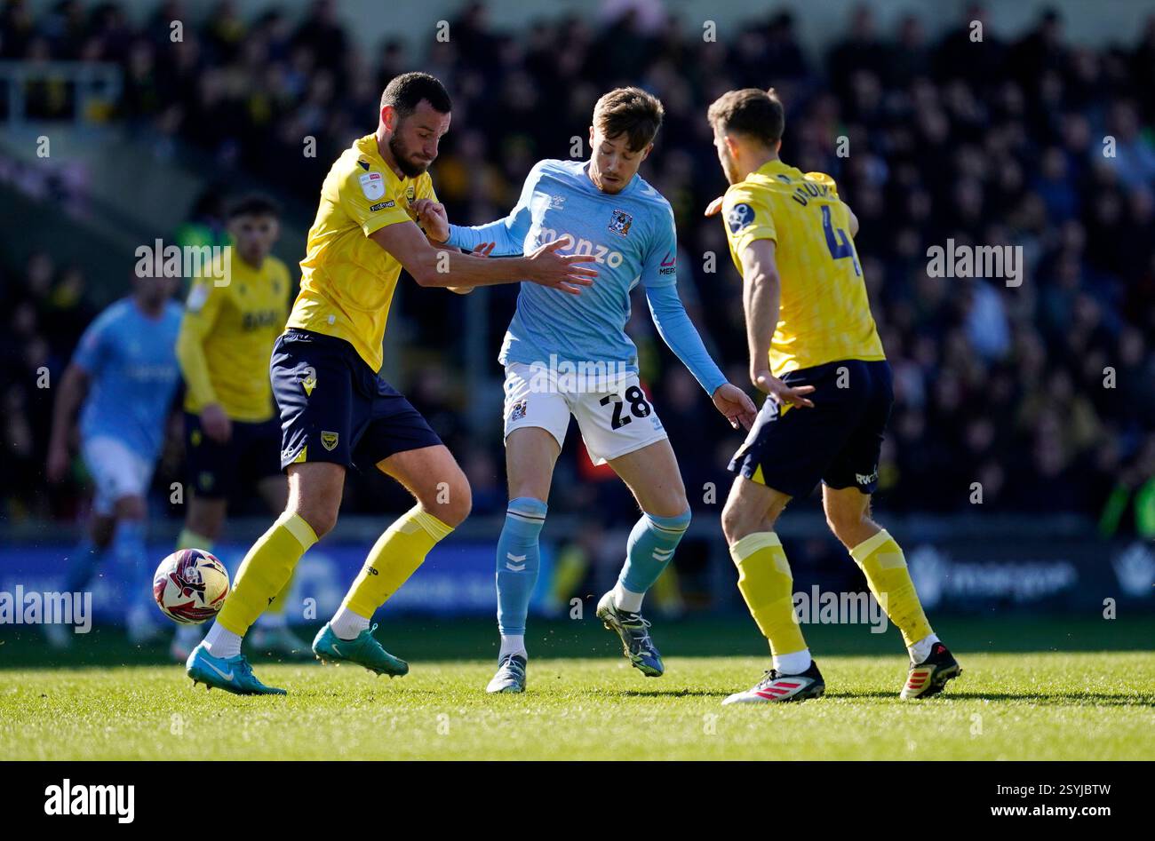 Coventry City's Josh Eccles (centre) battles for the ball with Oxford ...