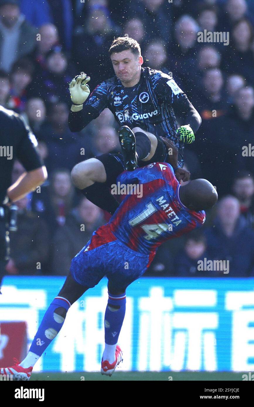 Millwall's goalkeeper Liam Roberts, atop, collides with Crystal Palace ...
