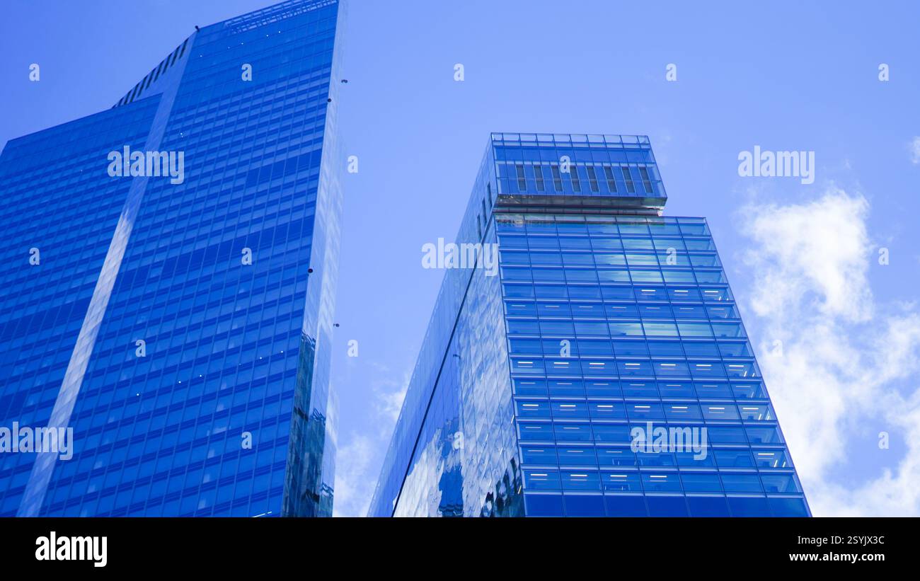 Contemporary high rise building with blue glass reflecting city ...
