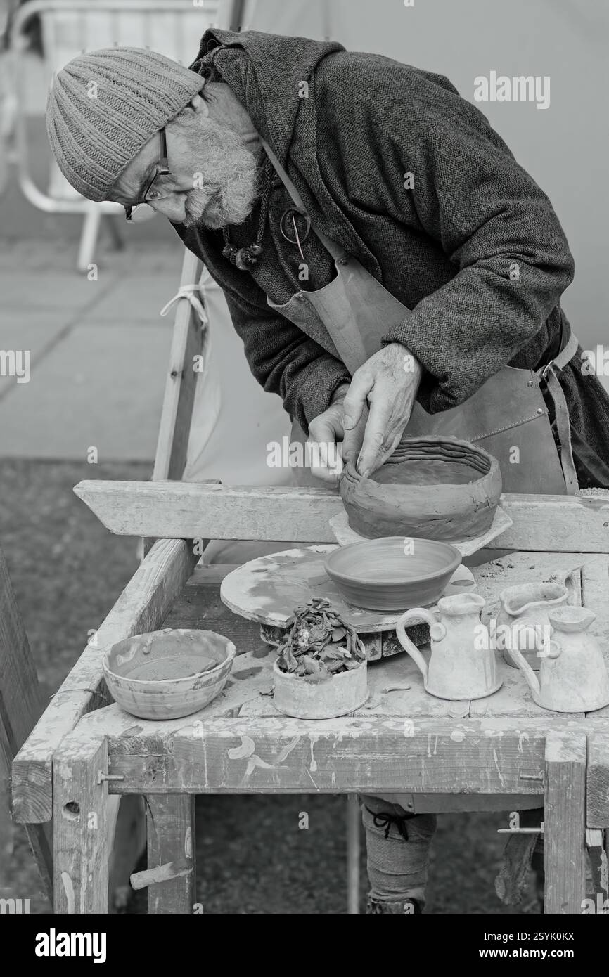A skilled artisan carefully shapes a clay pot, immersed in his ...