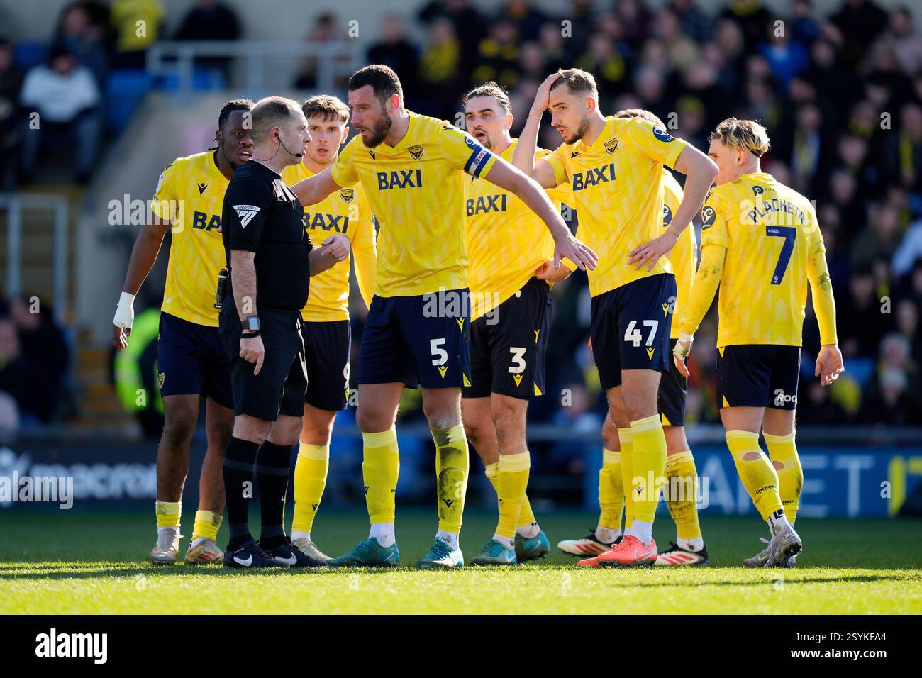 Oxford United's Elliott Moore (centre left) and team-mates speak to ...