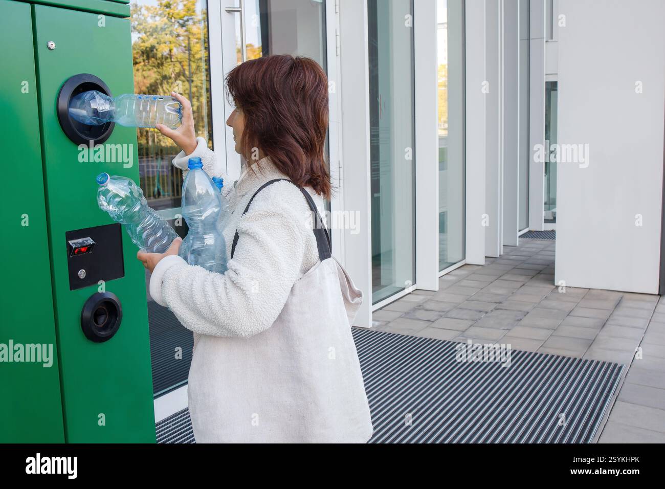 Woman returning plastic bottles to recycling vending machine Stock ...