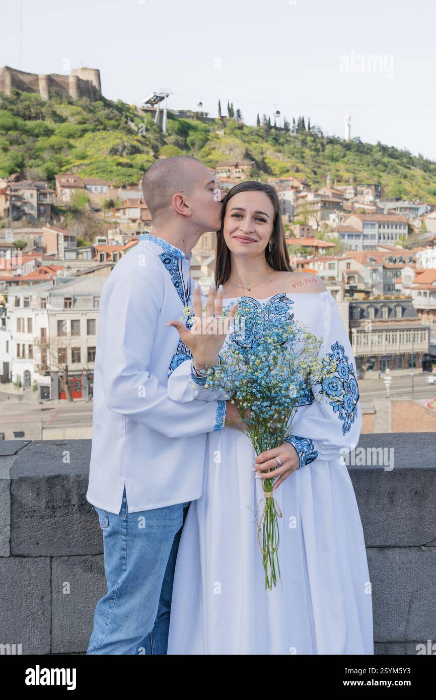 Engagement proposal in Tbilisi: Groom proposing to bride in traditional Ukrainian wedding attire ...
