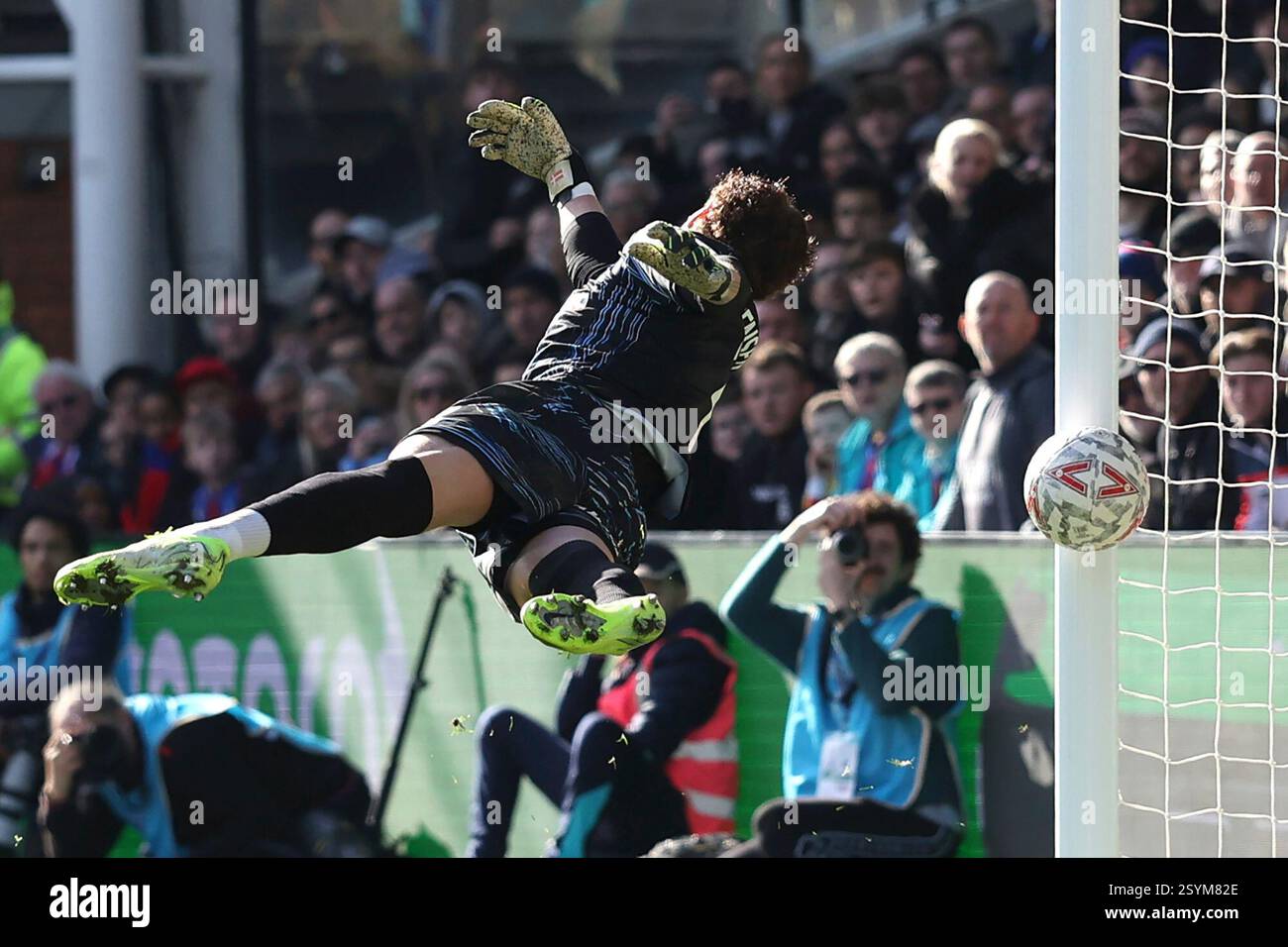 Millwall's goalkeeper Lukas Jensen dives but fails to save the goal ...