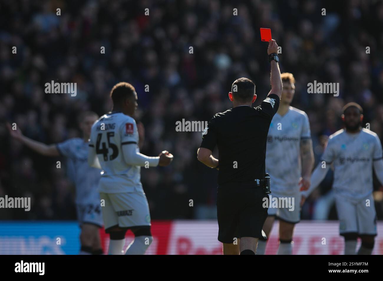LONDON, UK - 1st Mar 2025: Referee Michael Oliver shows a red card to ...