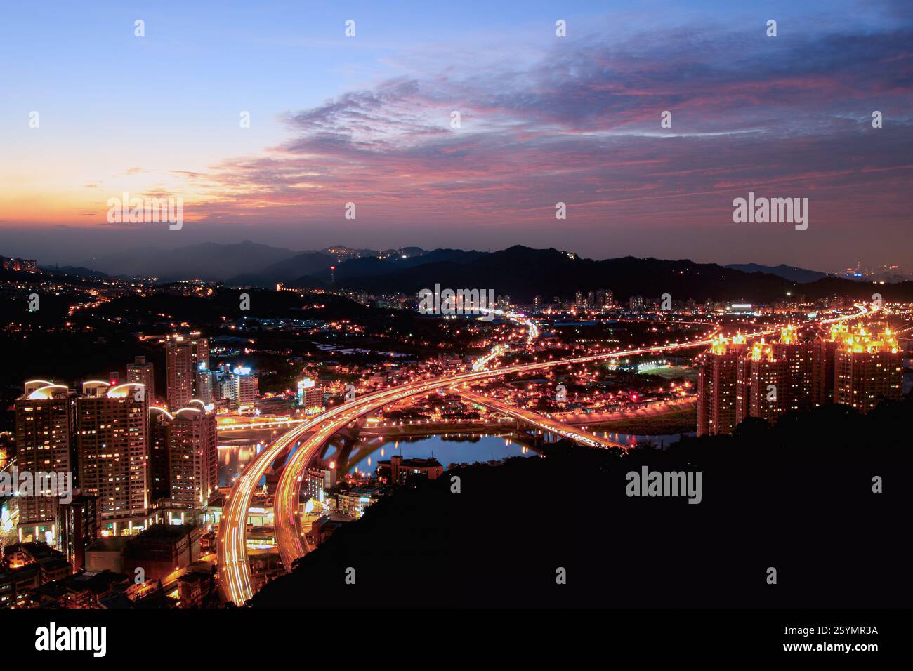 A stunning cityscape at dusk featuring brightly lit highways and high ...