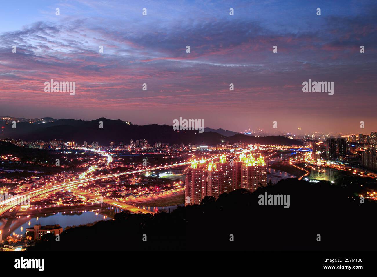 A stunning cityscape at dusk featuring brightly lit highways and high ...