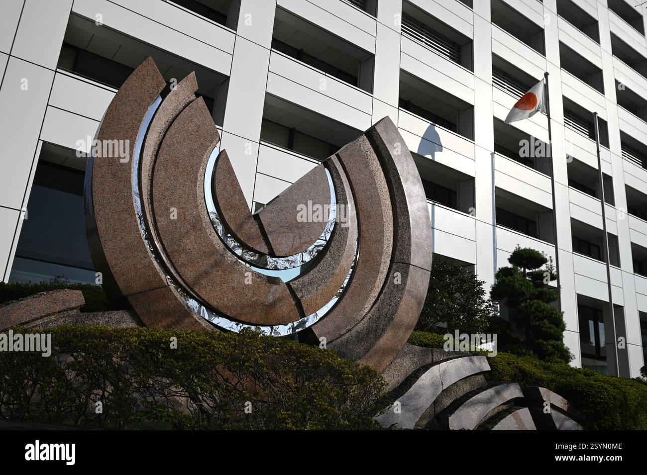 Japanese flag at the entrance of a modern solemn style skyscraper along ...