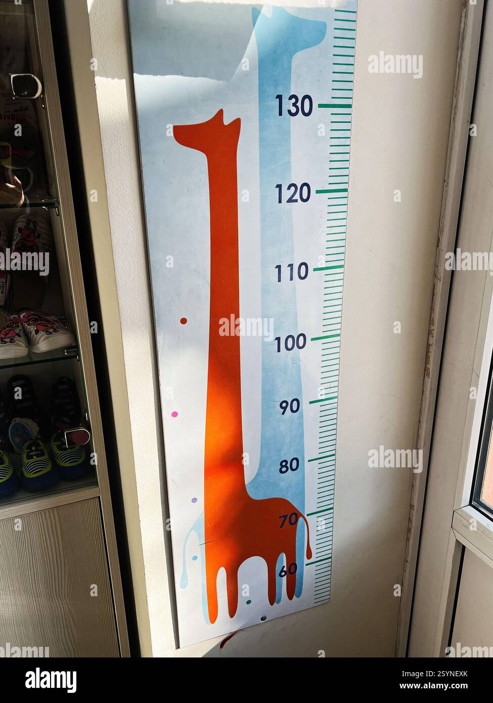 Playful giraffe themed height measurement chart against a white wall in ...
