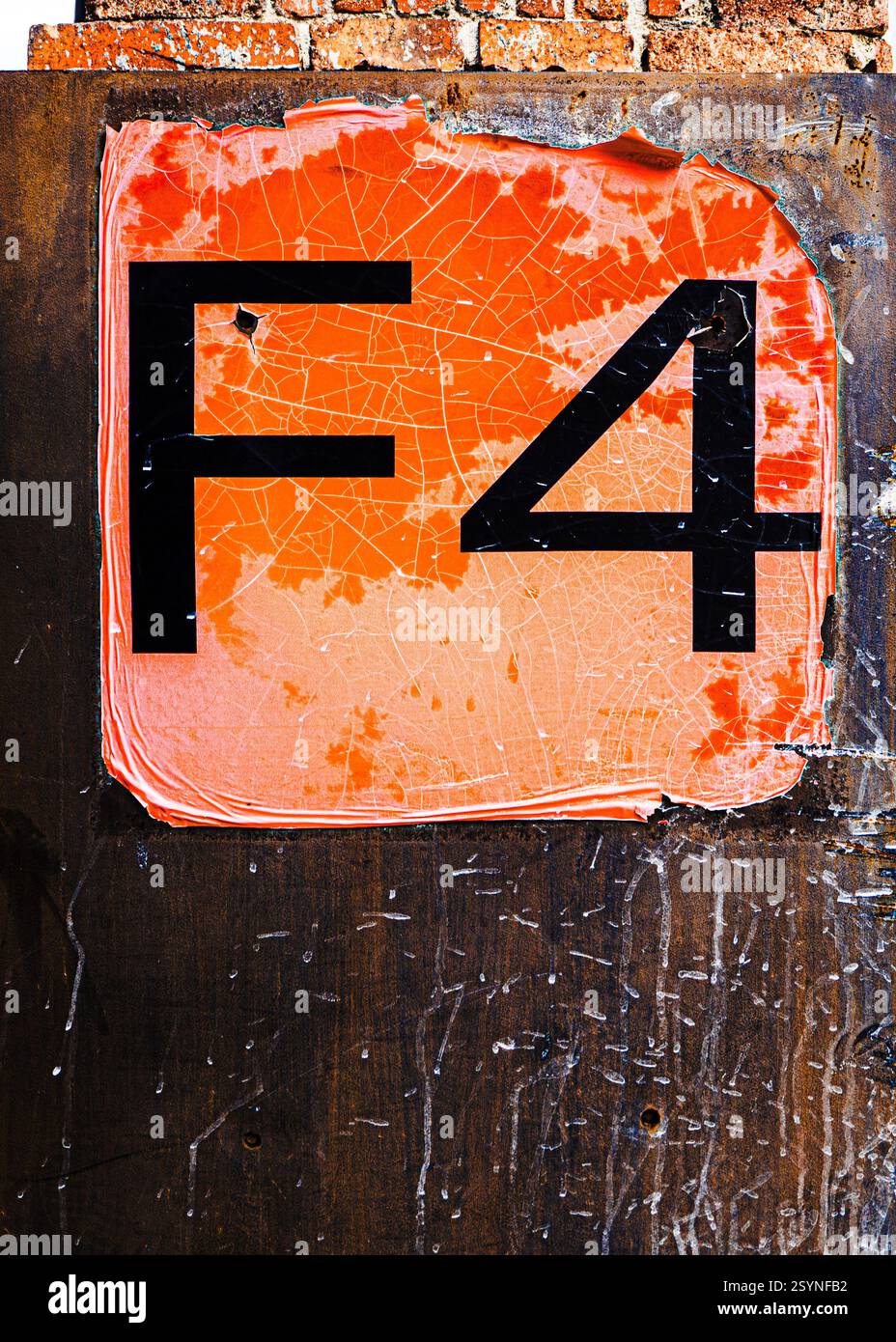 Close-up of a worn-out orange industrial sign with black “F4” lettering ...