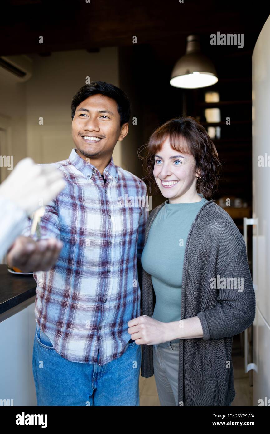 Happy couple smiles as they receive the keys to their new home, marking ...