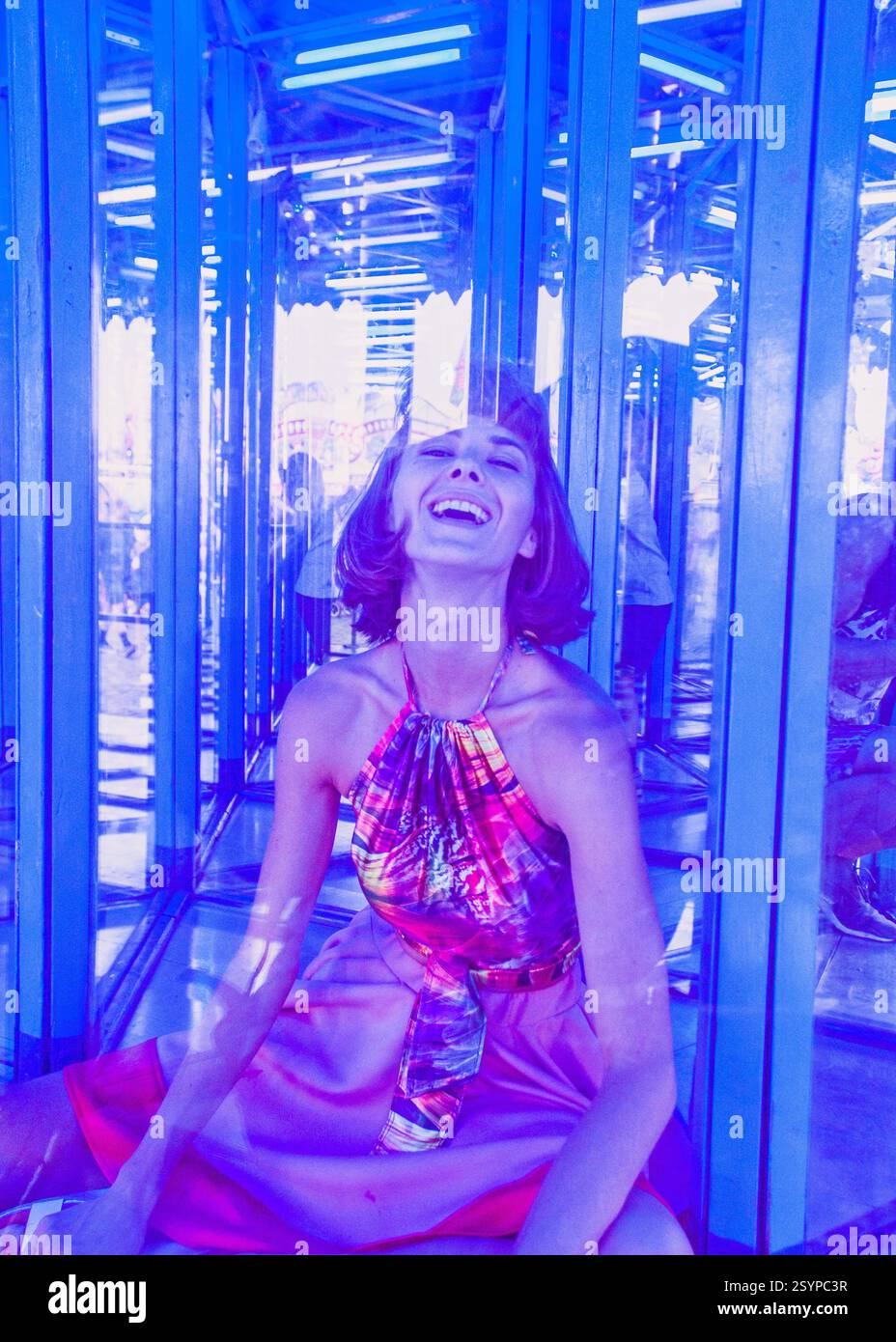 Sweet caucasian young woman sitting and posing in a mirror maze with ...