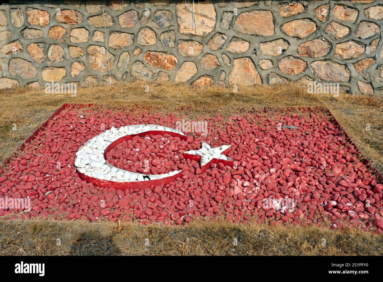 Turkish flag consisting of white and red pebbles placed on a grassy ...