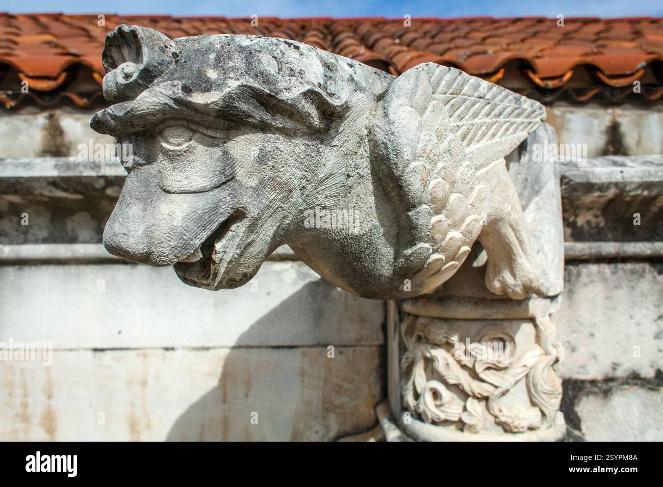 a close-up view of a weathered stone gargoyle with intricate details ...