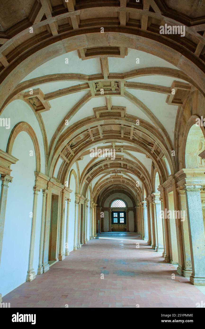 arched corridor with a tiled floor and sunlight streaming through the ...