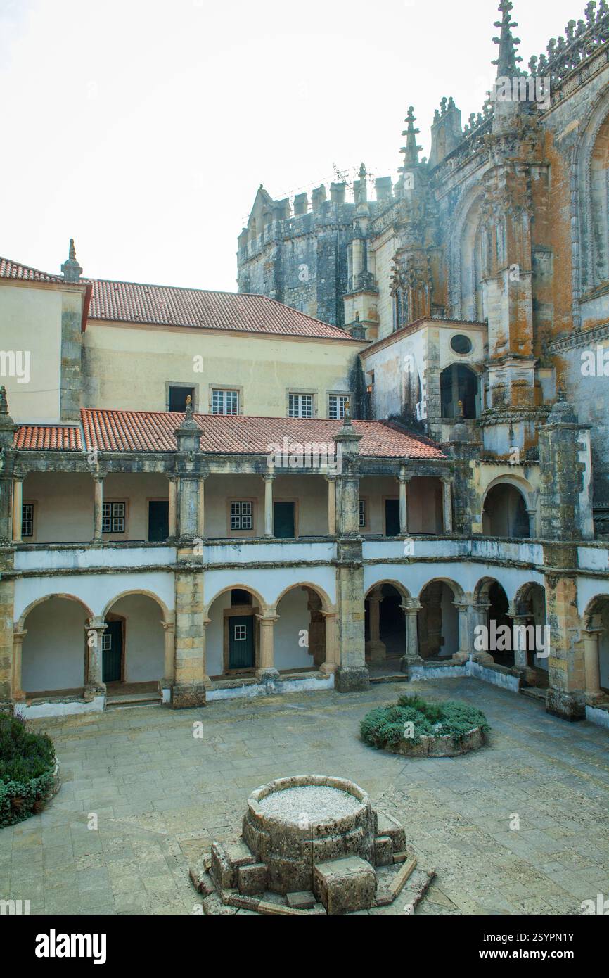 monastery courtyard, featuring a central fountain, arched cloisters ...