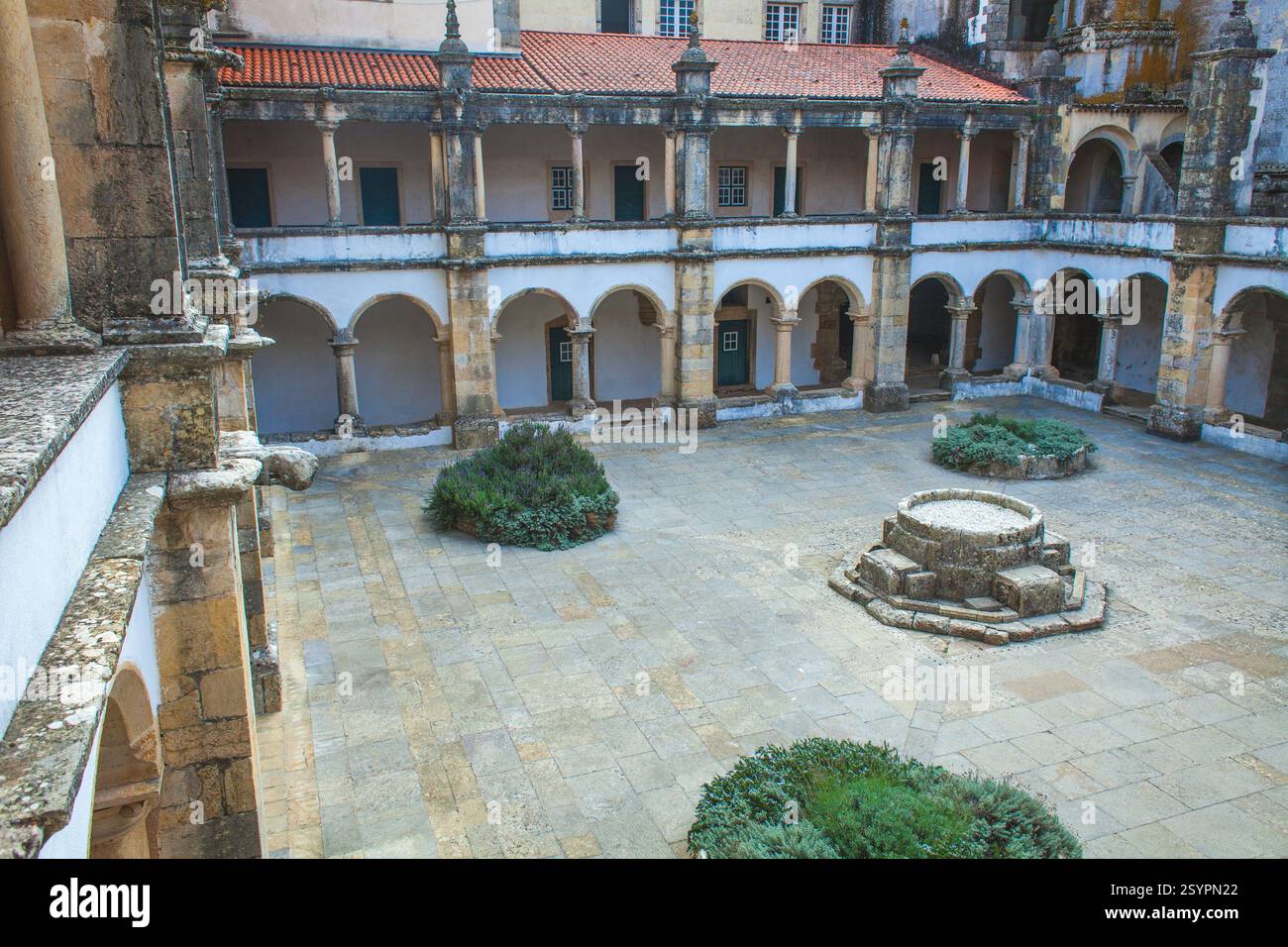 monastery courtyard, featuring a central fountain, arched cloisters ...