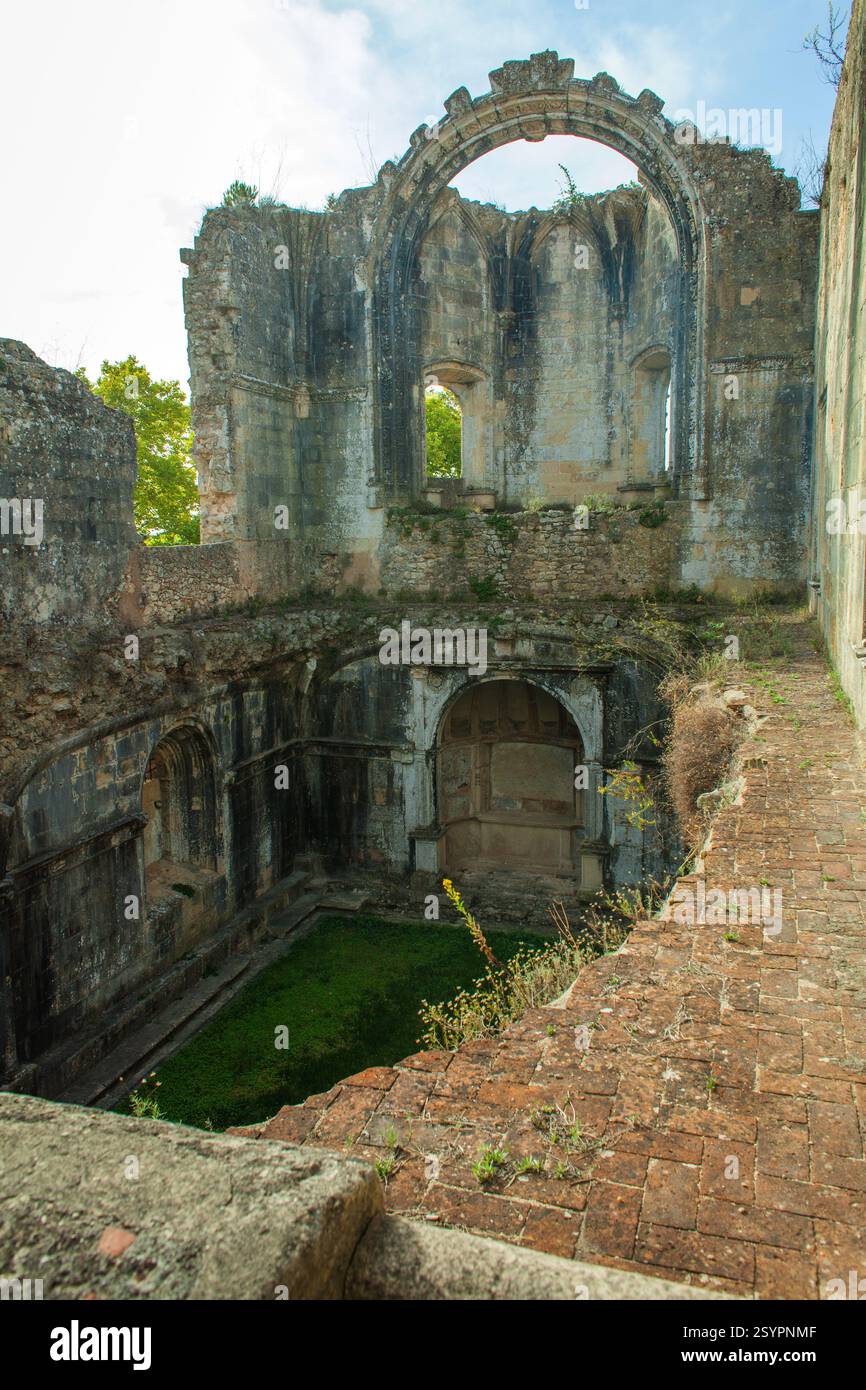 ruined interior space with crumbling walls, arched windows, and a patch ...