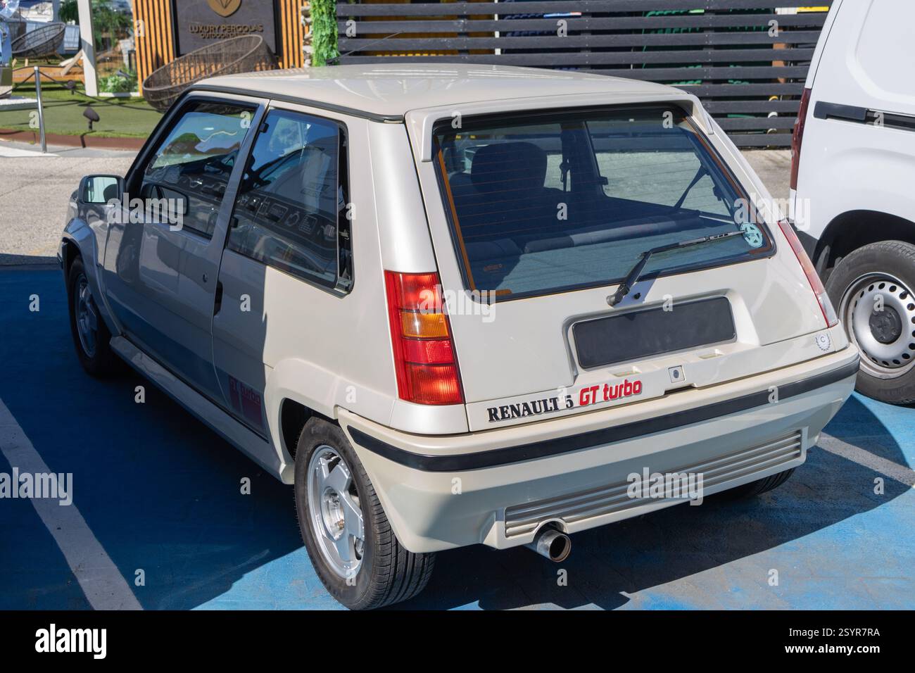 Rear view of a white renault 5 gt turbo parked on blue asphalt ...