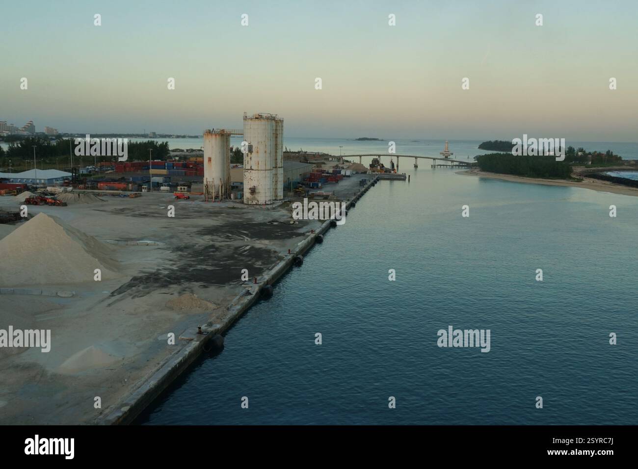 Pier equipped with fenders, industrial storage tanks and piles of ...