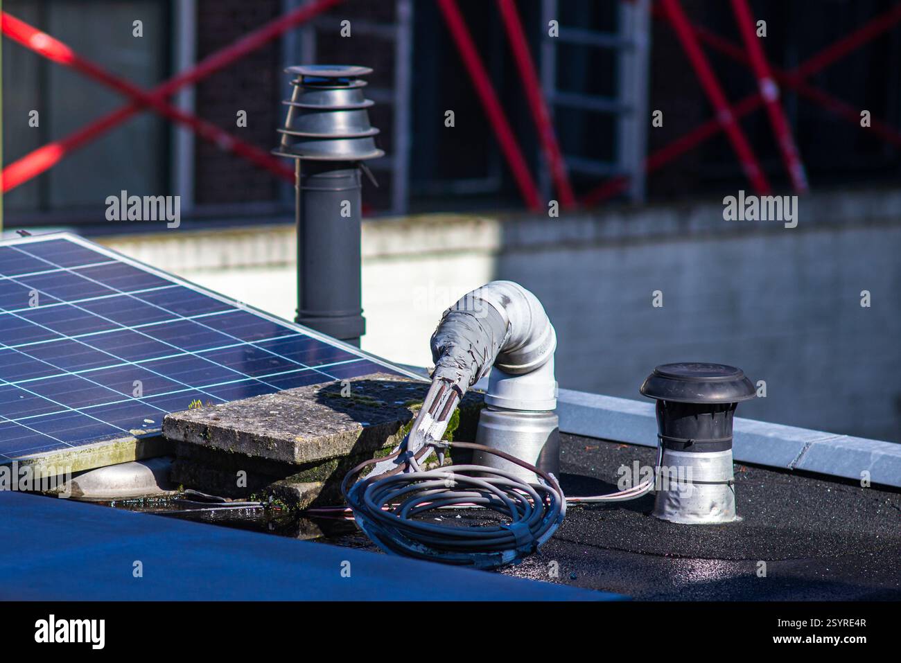 Solar panels and ventilation installations on the roof with red ...